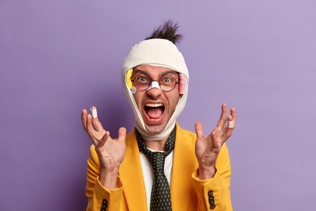 Irritated emotional man poses with angry expression, raises hands and ...